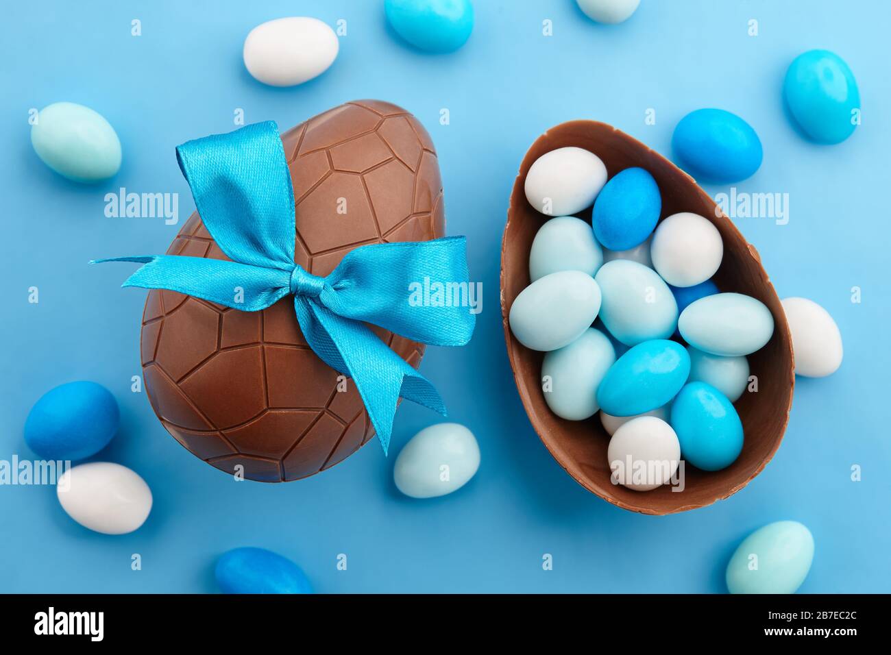 Chocolate Easter egg with blue and white candies Stock Photo - Alamy
