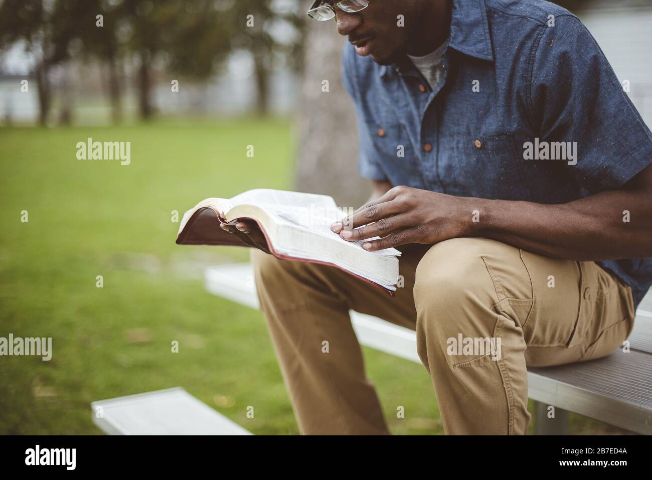 African reading bible in park hi-res stock photography and images - Alamy
