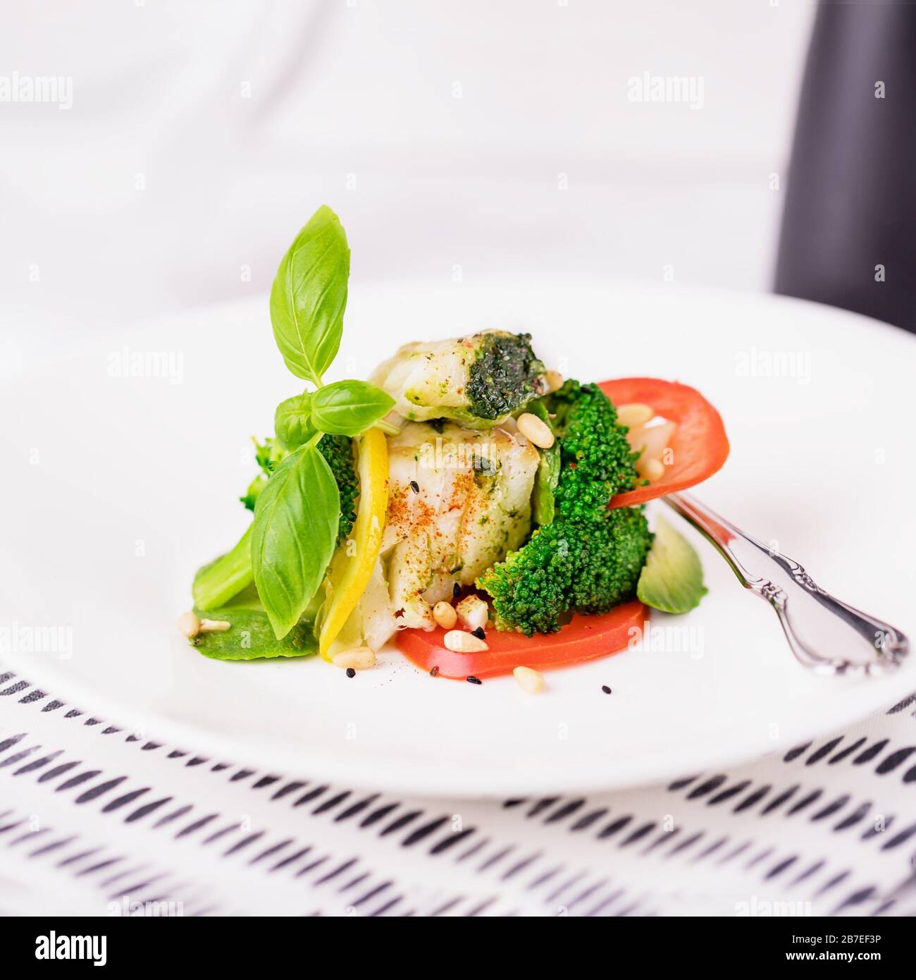Steamed cod fish fillet with broccoli, tomato, lemon, avocado, basil ...
