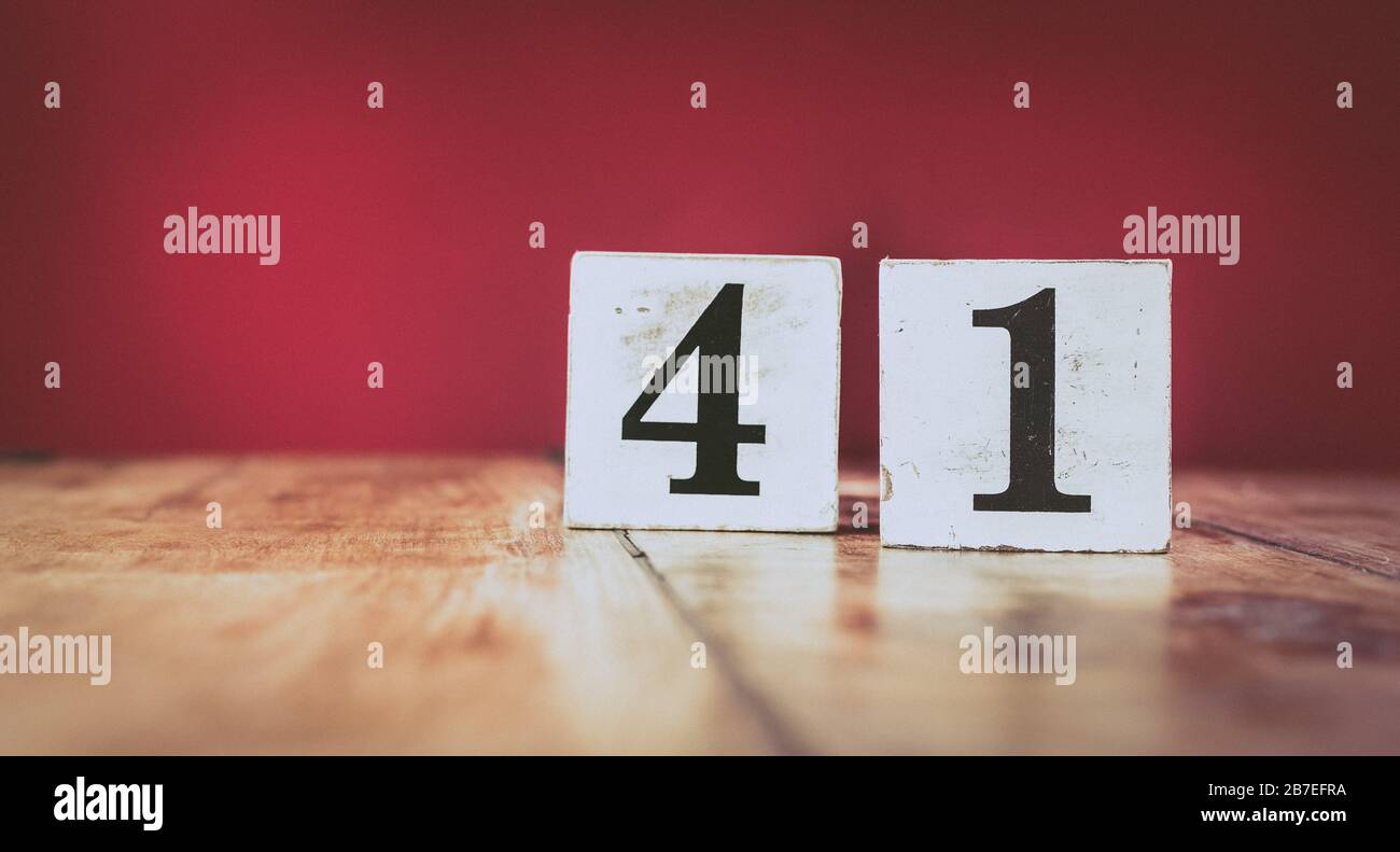 Number 41 on a vintage wooden table and dark maroon background - retro ...