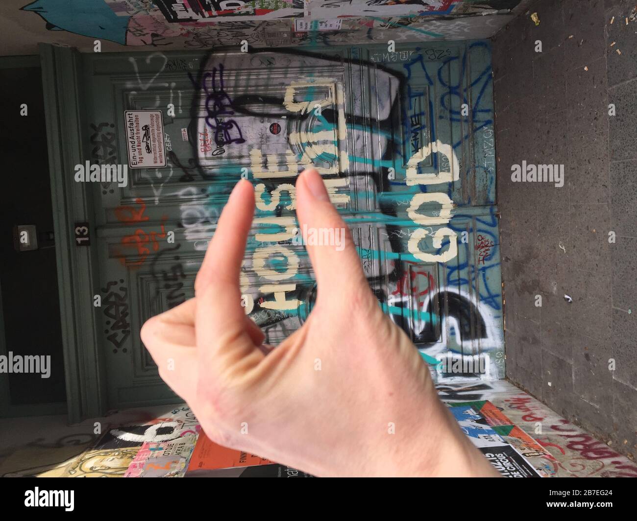 Vertical shot a person's fingers in front of a painting on the wall ...