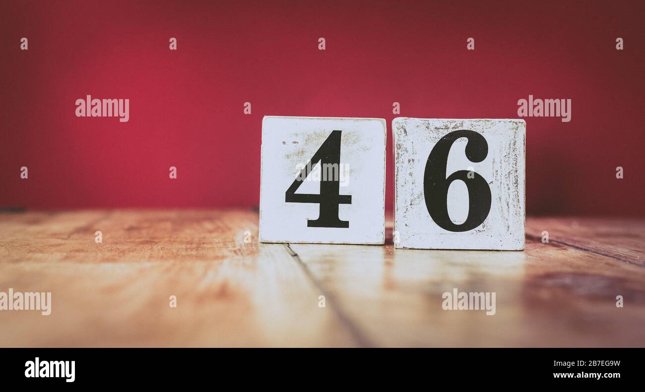 Number 46 on a vintage wooden table and dark maroon background - retro ...
