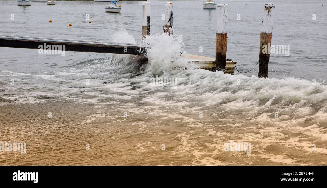 Waves of the ocean reaching the wooden docks Stock Photo - Alamy