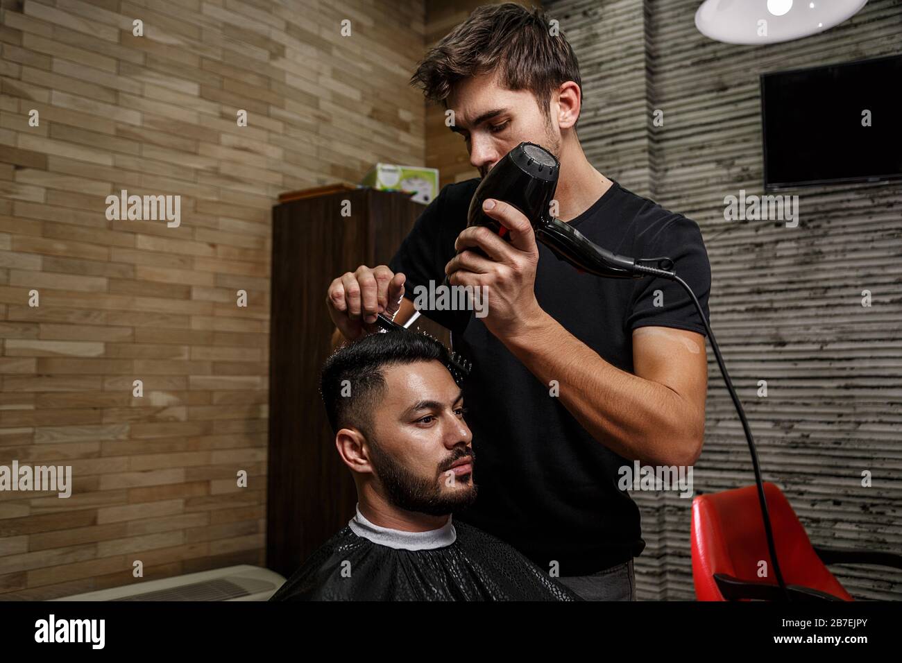 a brutal-looking Barber cuts the hair of an Indian guy. cinematic image ...