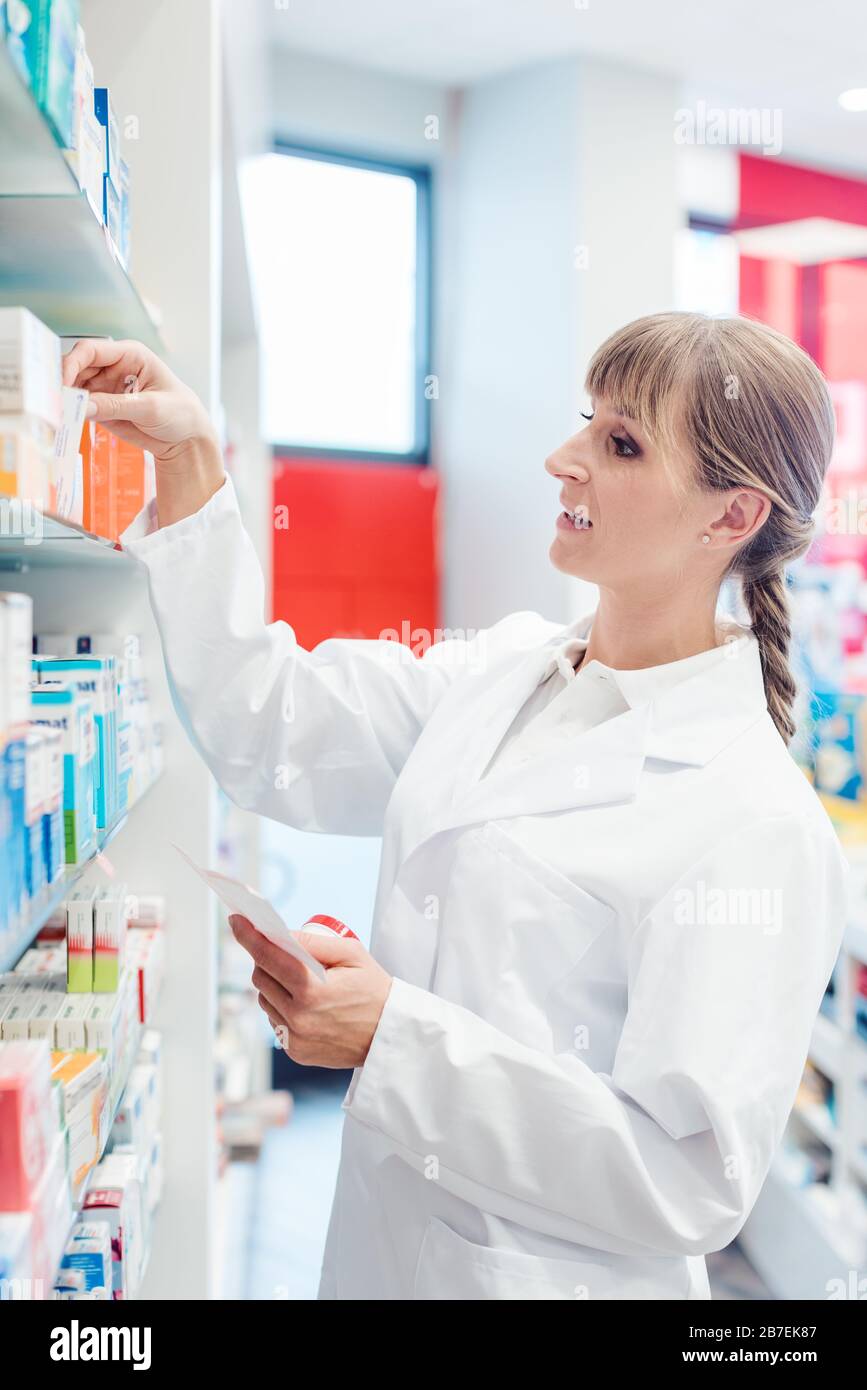 Pharmacist or Chemist woman sorting drugs in shelves in her pharmacy ...