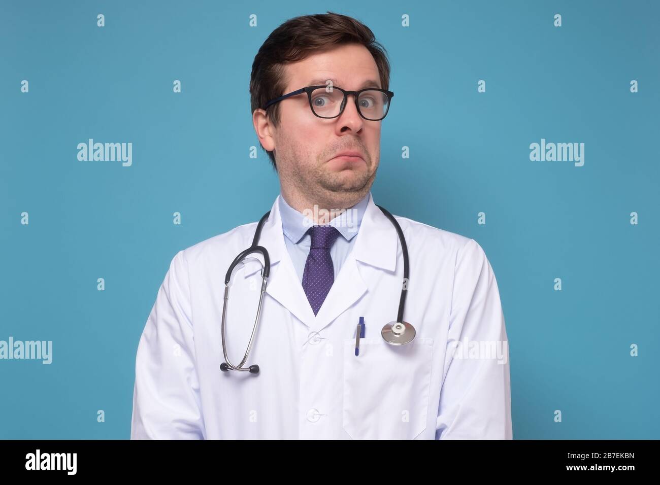 Puzzled caucasian male doctor with glasses and stethoscope is uncertain ...