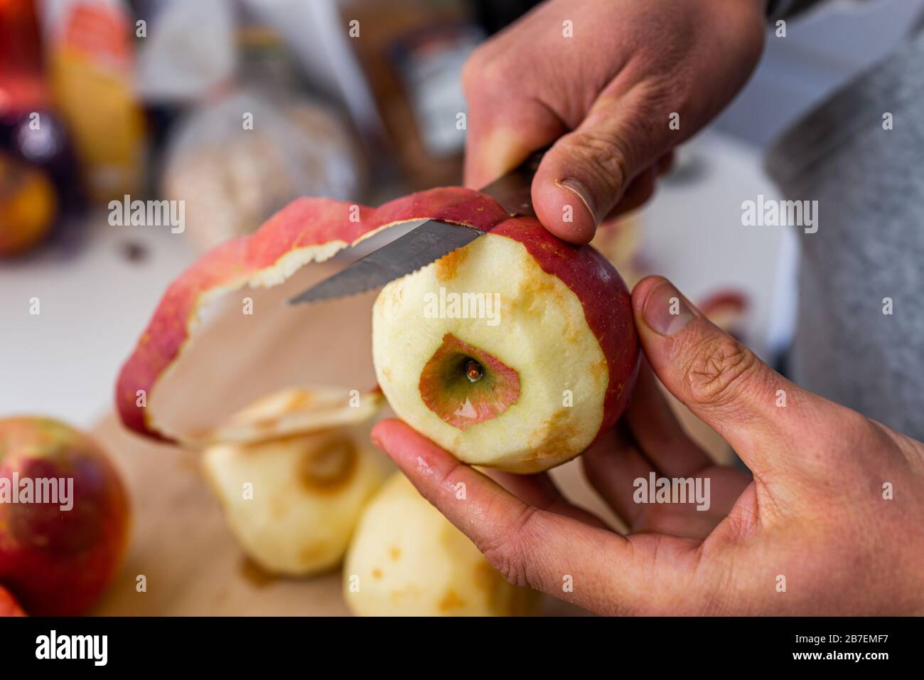 Macro closeup of wooden chopping cutting board and person hands peeling ...