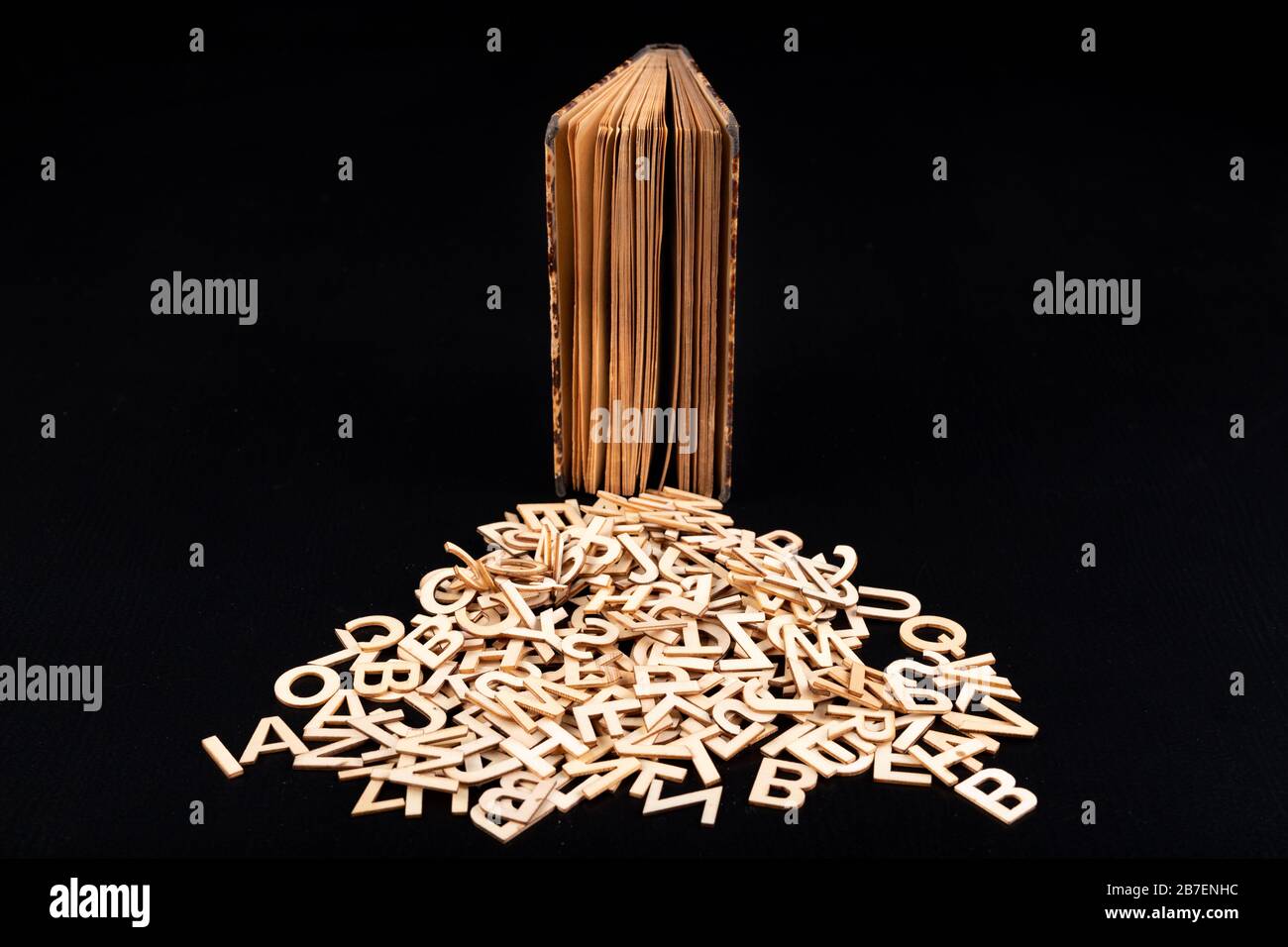 Old book and wooden letters. Wooden letters spilling out of the book ...