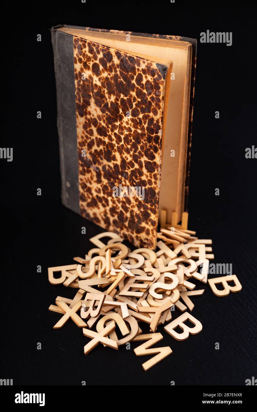 Old book and wooden letters. Wooden letters spilling out of the book ...