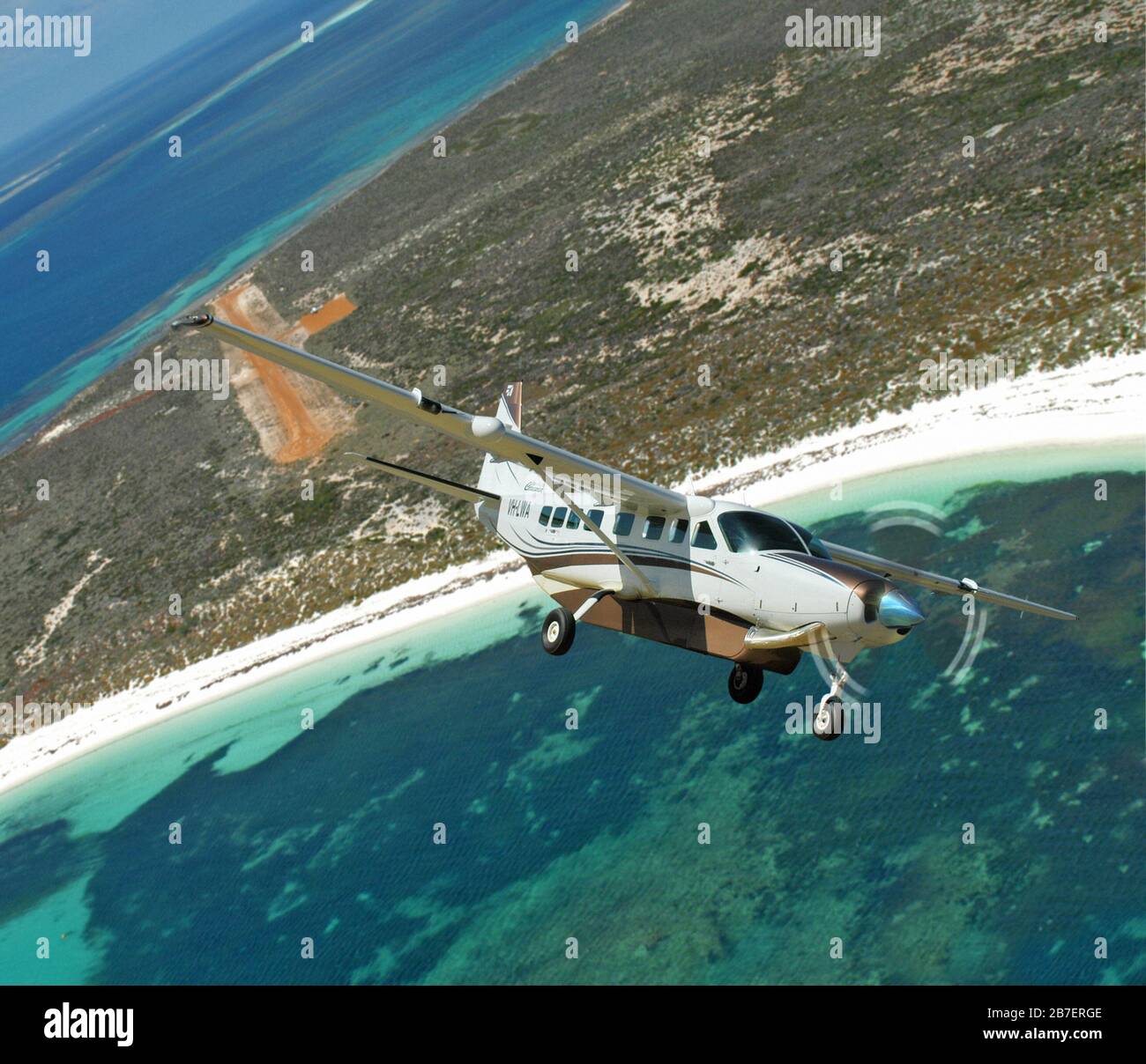 Air to air portrait of a Cessna 280 Caravan taking off from a red earth ...