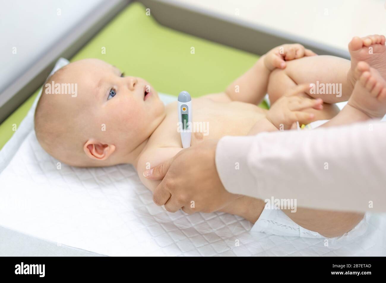 Doctor pediatrist examining child. pediatrician taking baby temerature ...