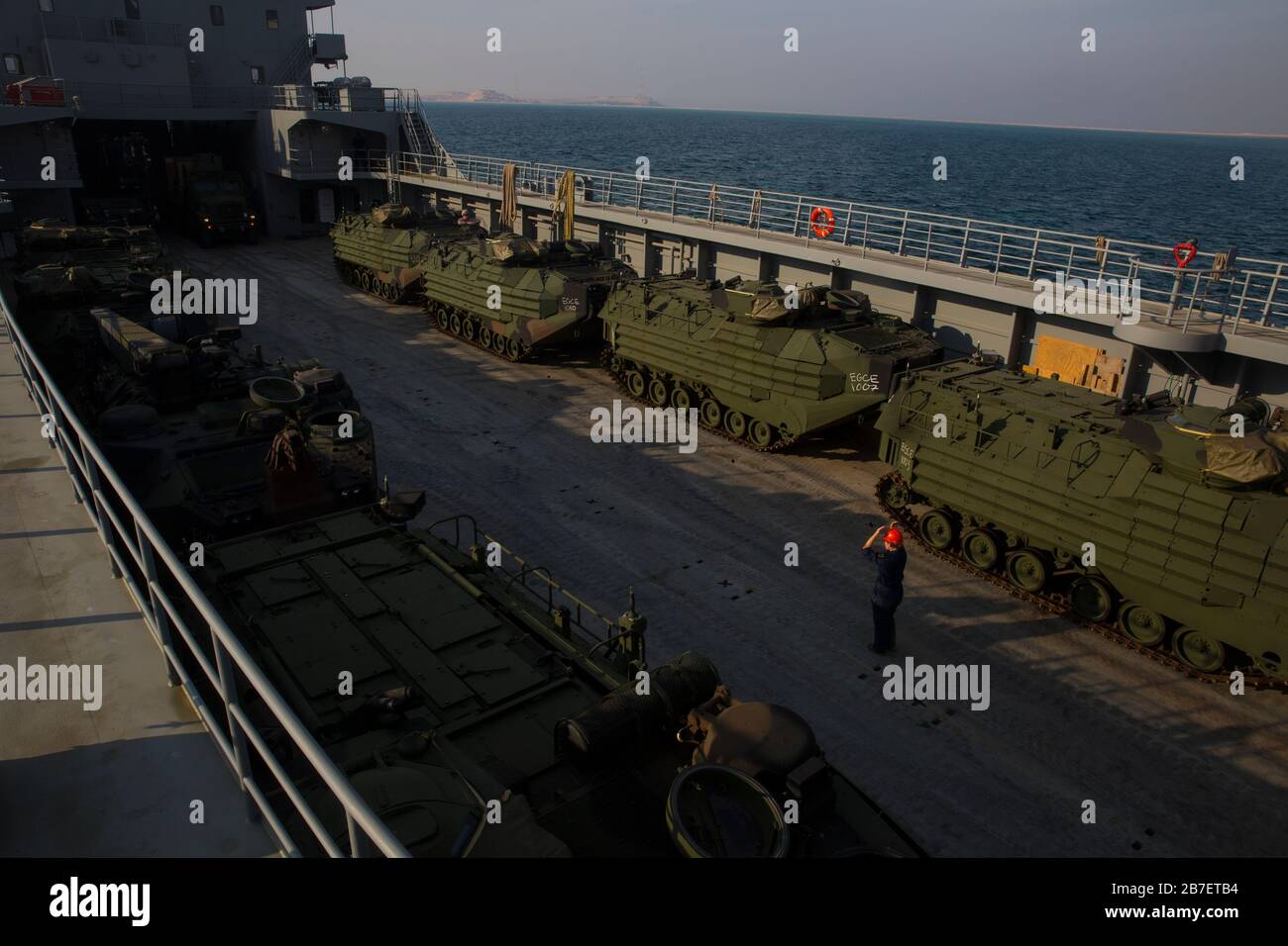 A U.S. Army Soldier guides a crane off of the Logistics Support Vessel ...