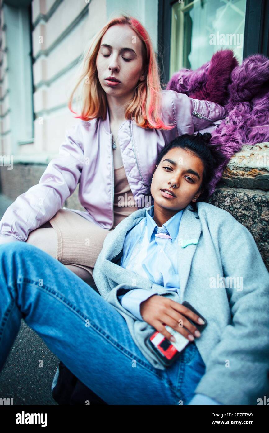 Two teenage girls infront of university building smiling, having fun ...