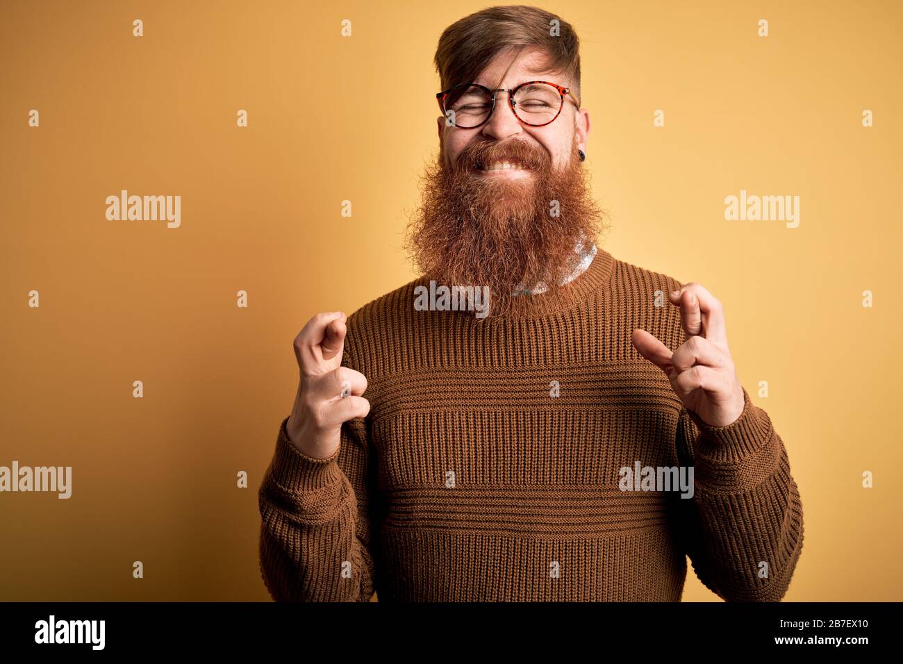 Handsome Irish redhead man with beard wearing glasses and winter ...
