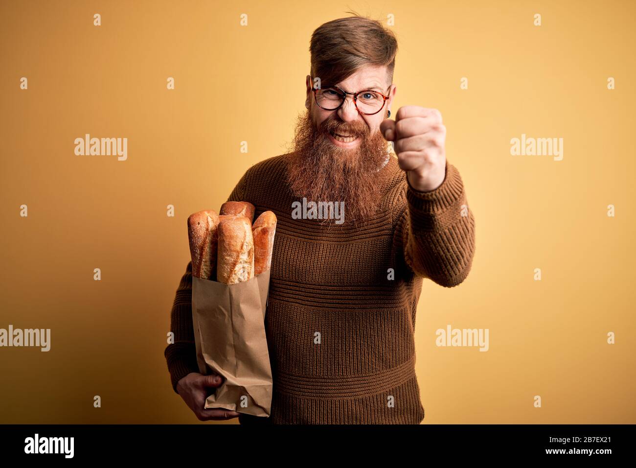 Irish redhead man with beard holding groceries paper bag of bread over ...