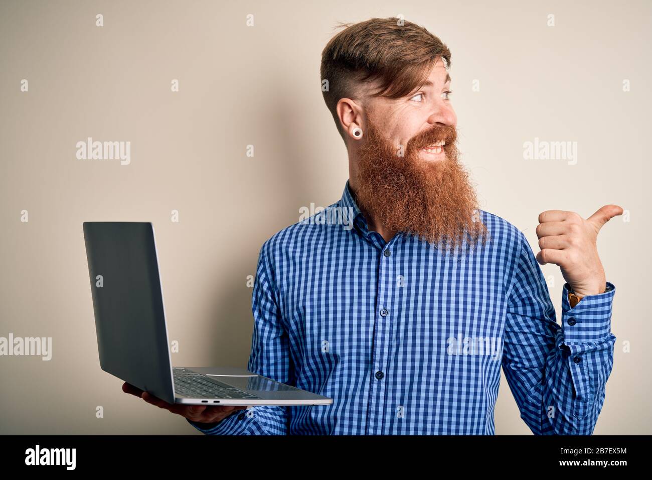 Redhead Irish business man with beard using computer laptop over ...