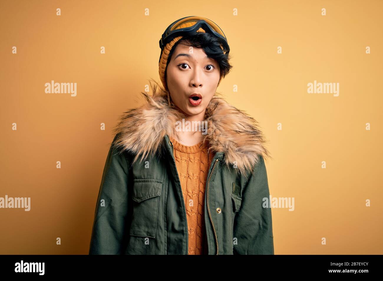 Beautiful asian skier girl wearing snow sportswear using ski goggles ...