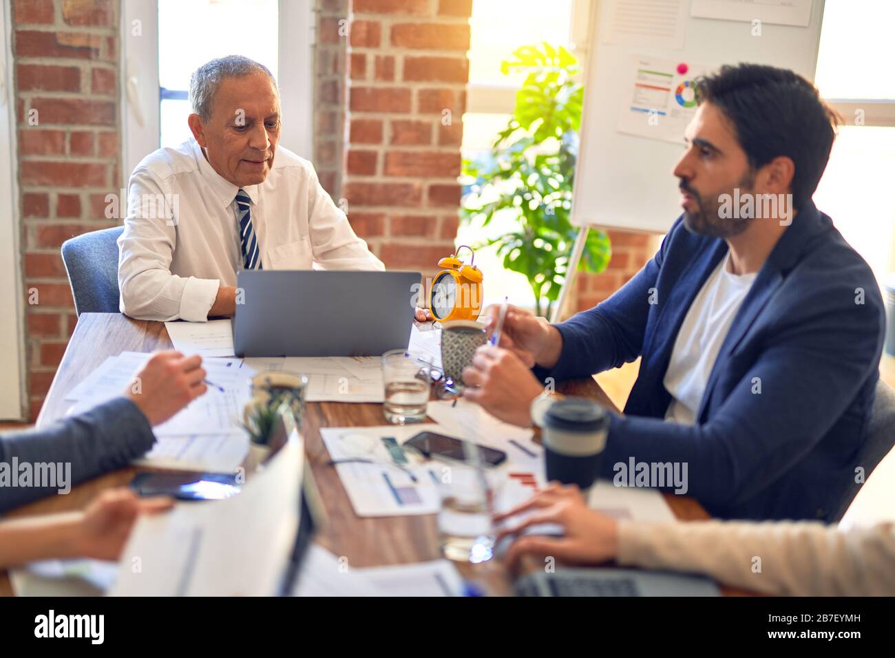 Group of business workers working together. Sitting on desk using ...
