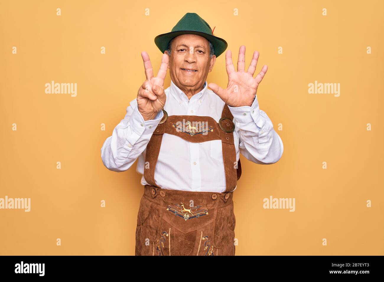 Senior grey-haired man wearing german traditional octoberfest suit over ...