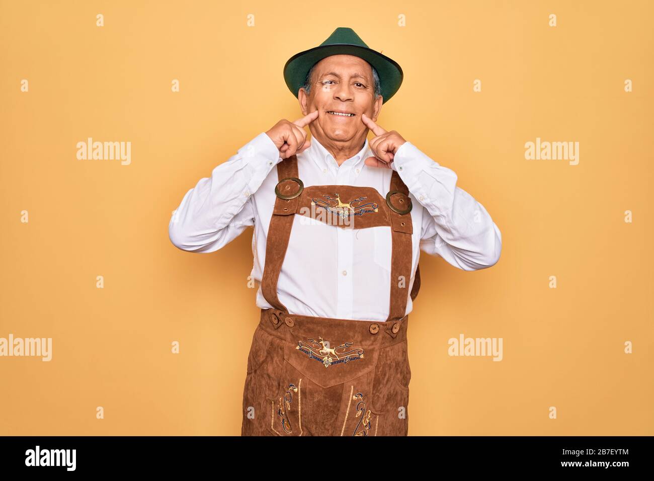 Senior grey-haired man wearing german traditional octoberfest suit over ...