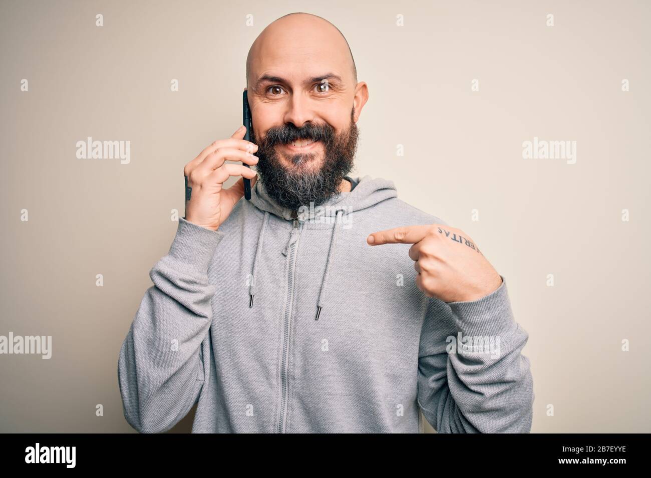 Handsome bald man with beard having conversation talking on the ...