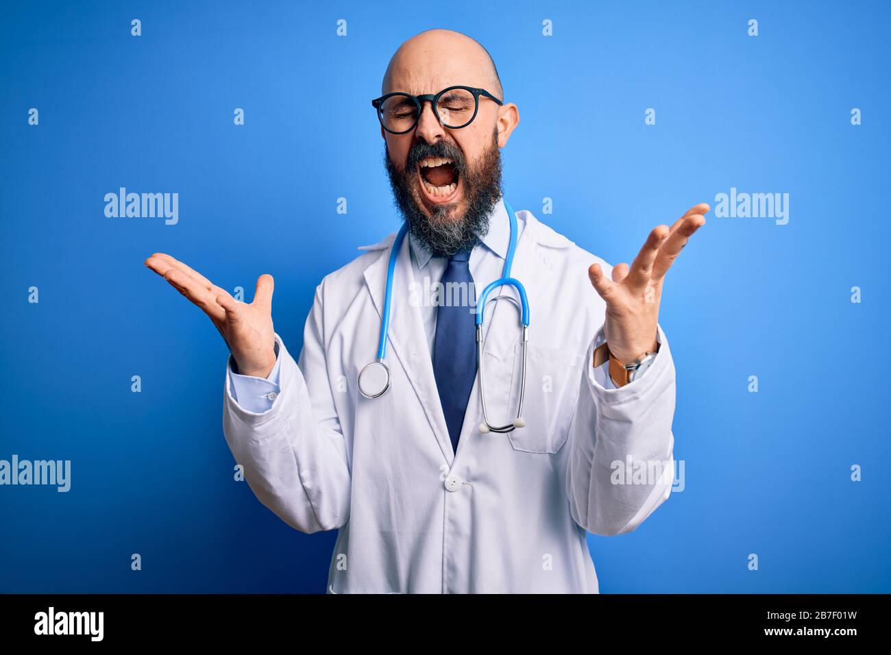 Handsome bald doctor man with beard wearing glasses and stethoscope ...