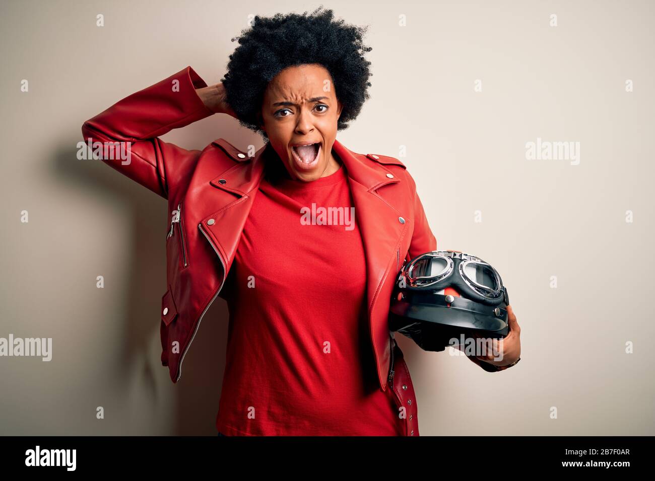 Young African American afro motorcyclist woman with curly hair holding ...