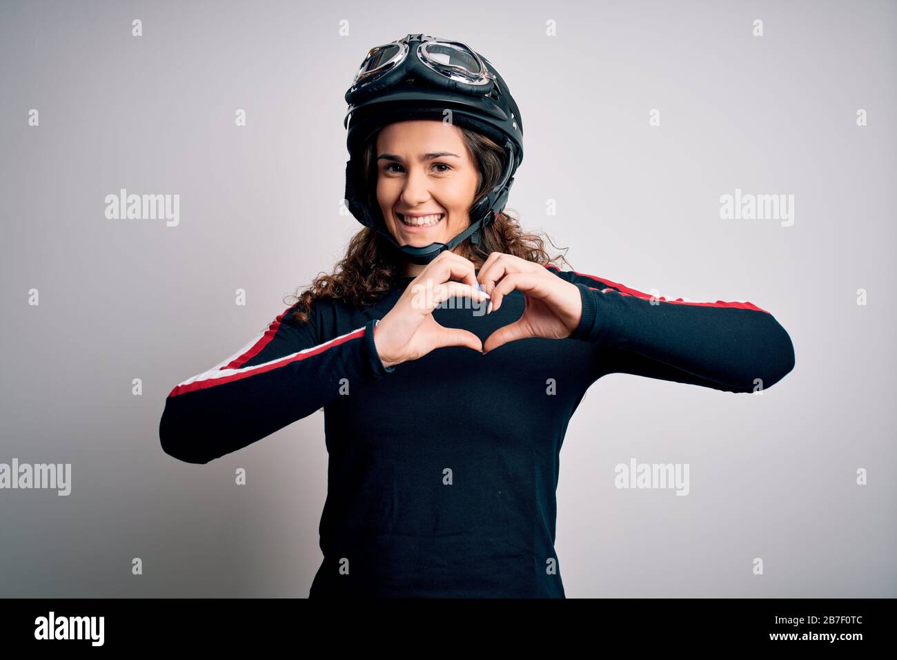 Beautiful motorcyclist woman with curly hair wearing moto helmet over ...