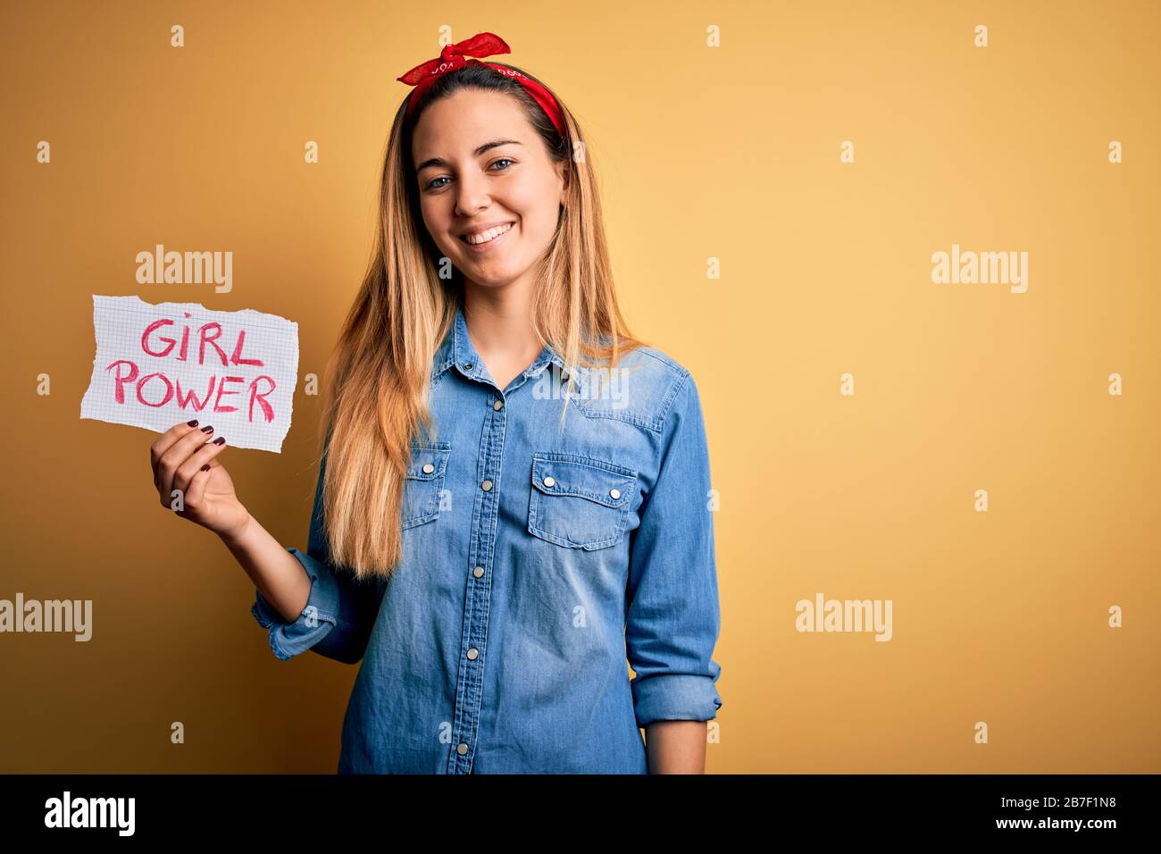 Blonde woman with blue eyes asking for girls rights holding banner with ...