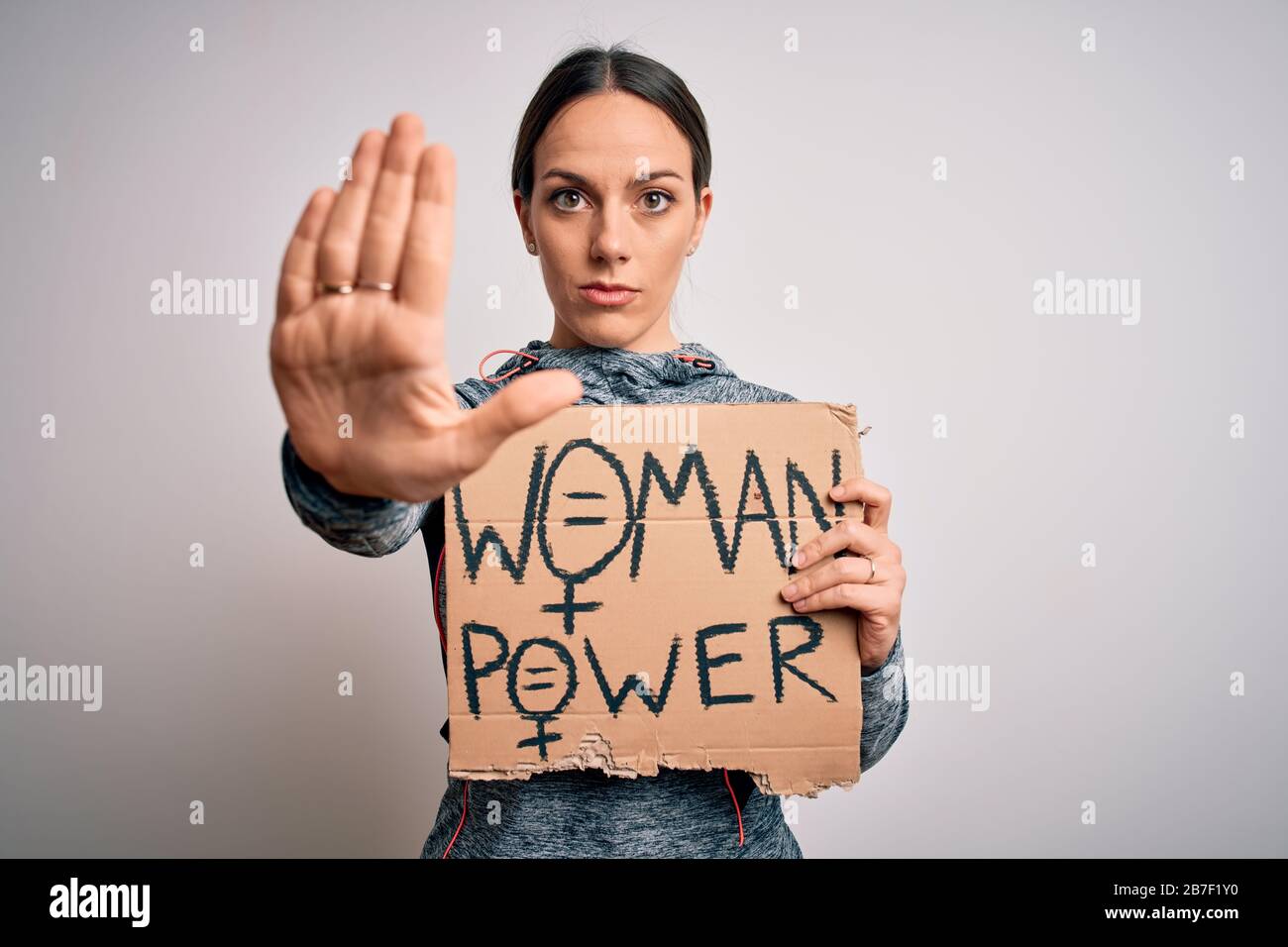 Young fitness woman wearing sport clothes holding protest cardboard for ...