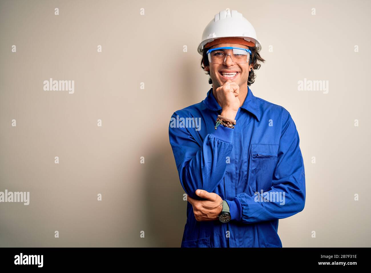 Young constructor man wearing uniform and security helmet over isolated ...