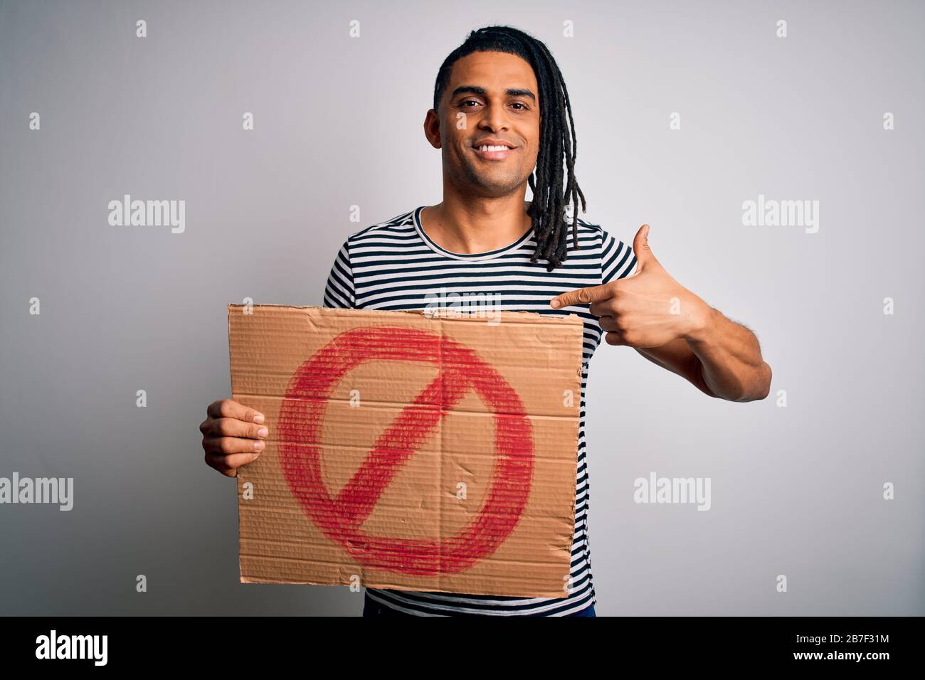 Young handsome african american man with dreadlocks holding banner with ...