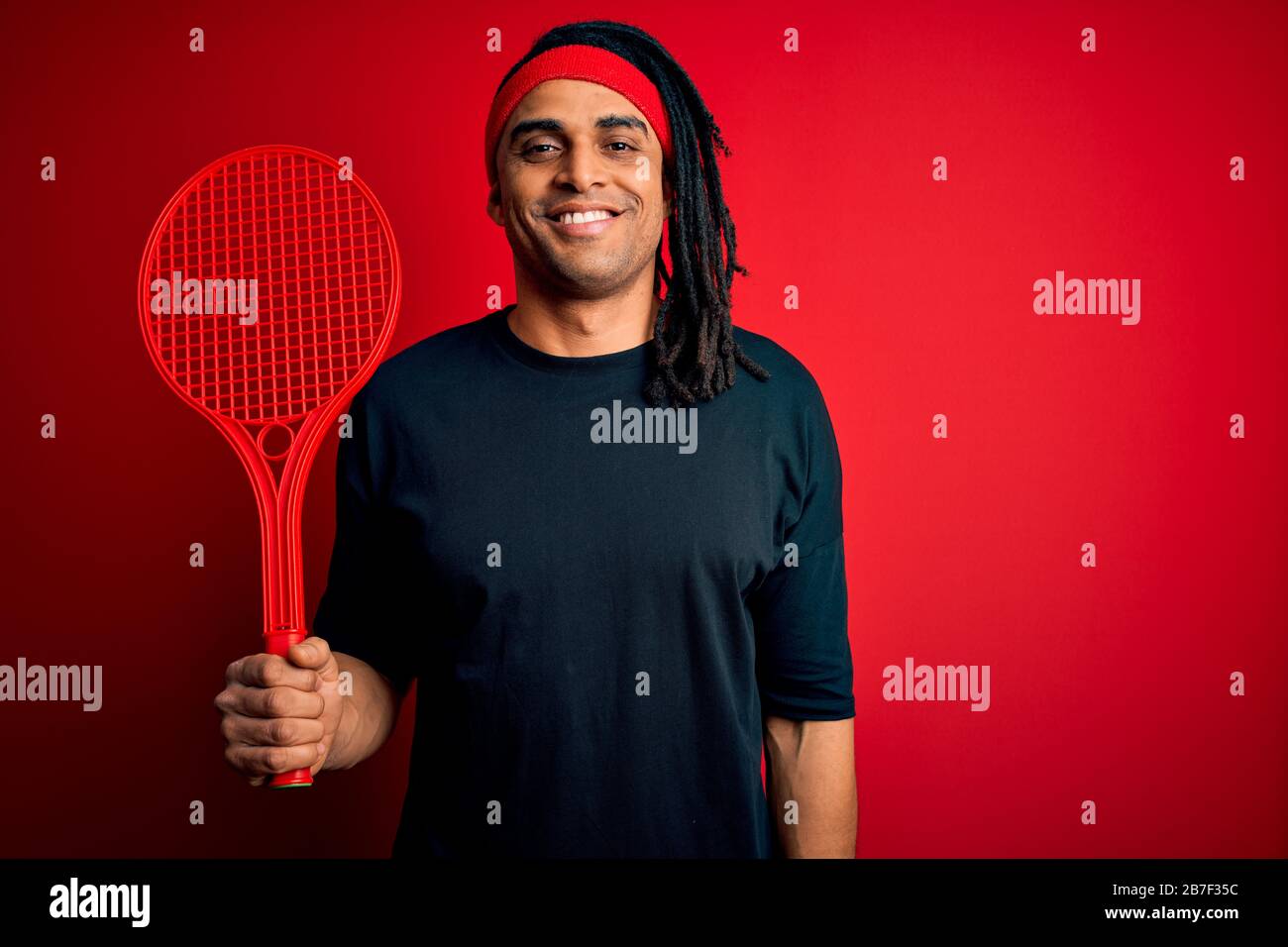 African american afro sportsman with dreadlocks holding tennis racket ...