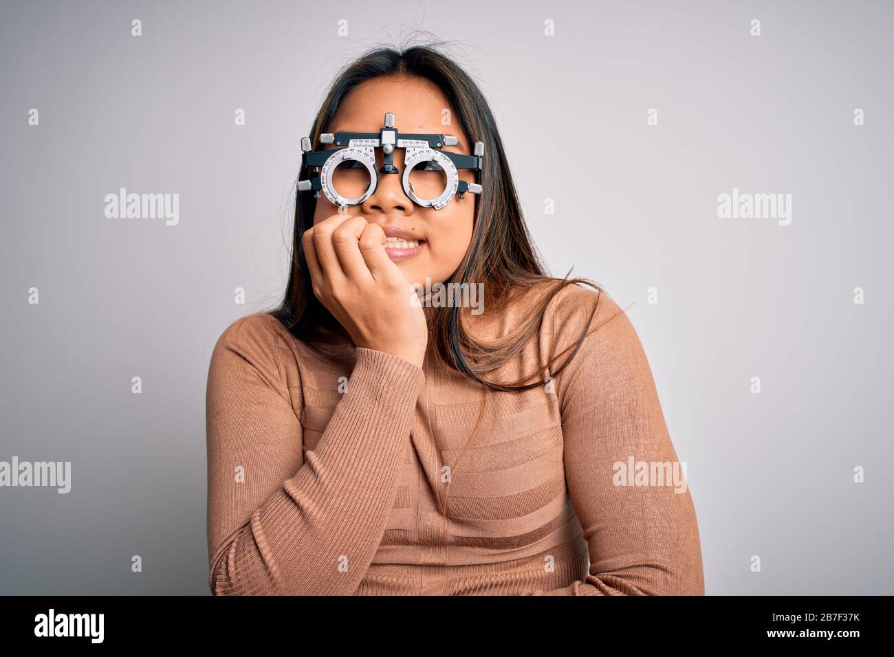 Young asian optical girl controlling eyesight using optometry glasses ...