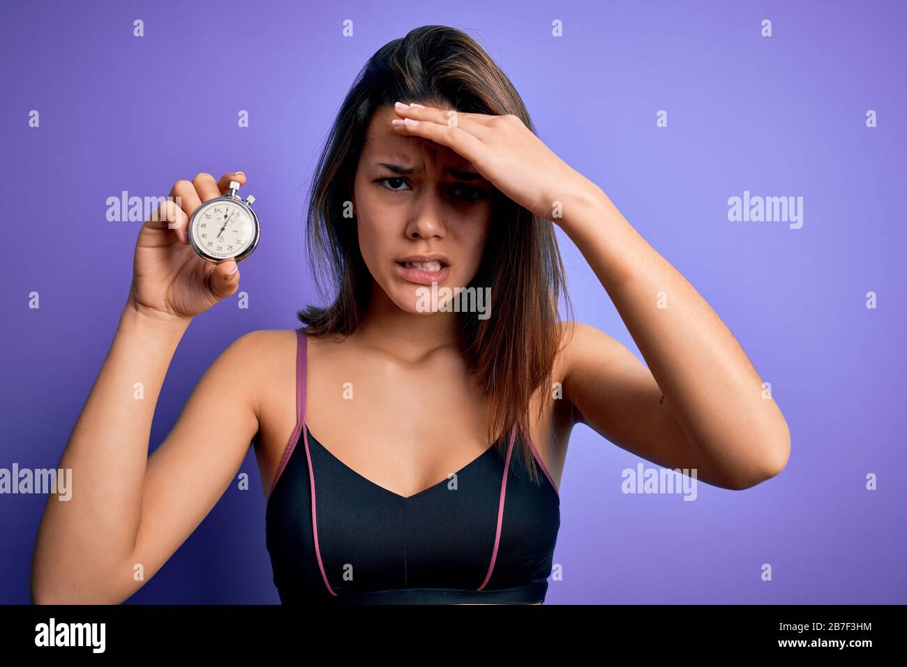 Young beautiful sporty girl doing sport using stopwatch over isolated ...