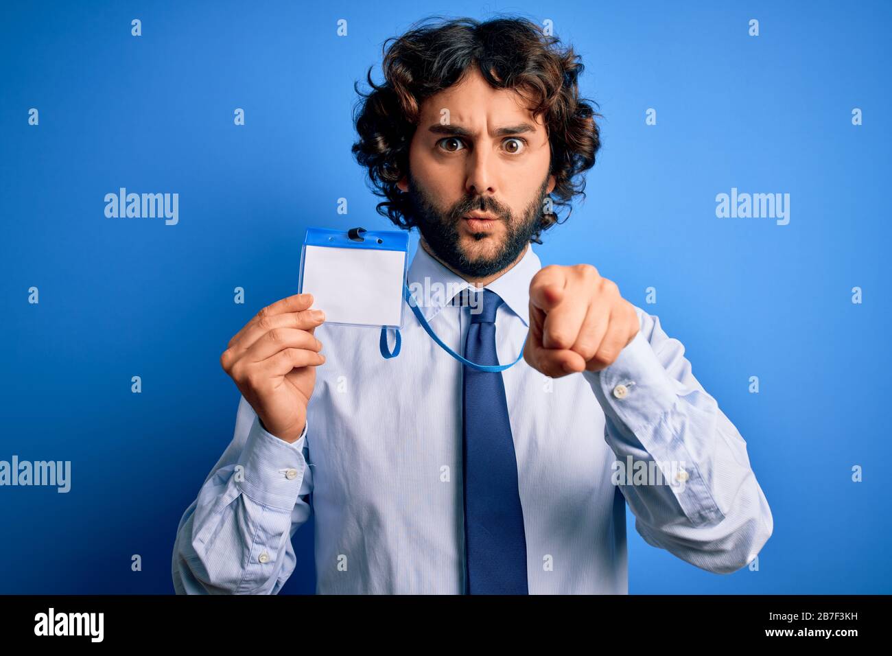 Young handsome business man with beard holding id card identification ...