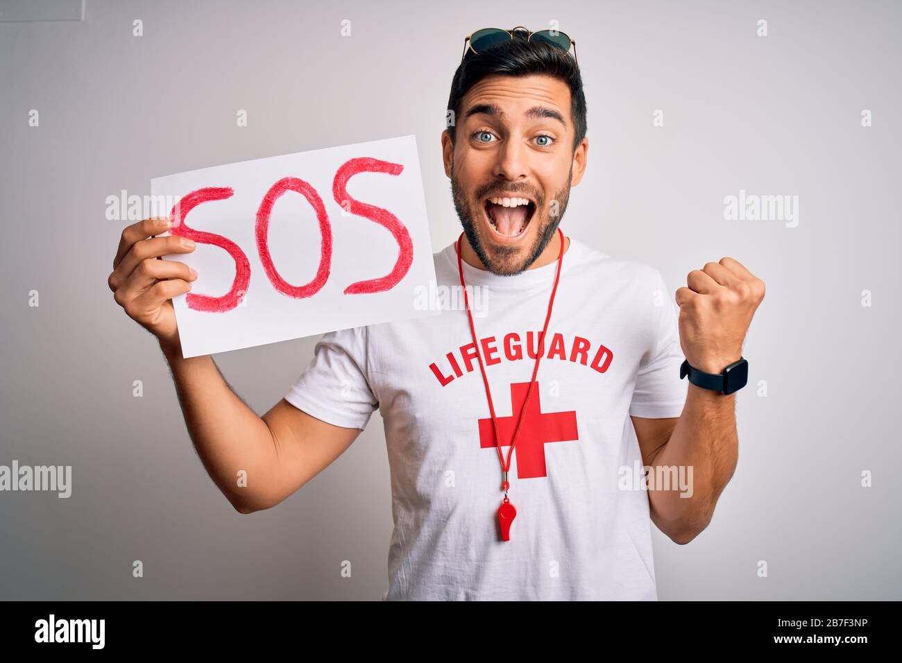 Young lifeguard man with beard wearing whistle holding paper with sos ...