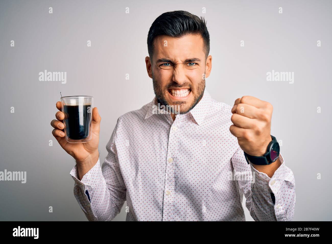 Young handsome man drinking a cup of hot coffee over white isolated ...