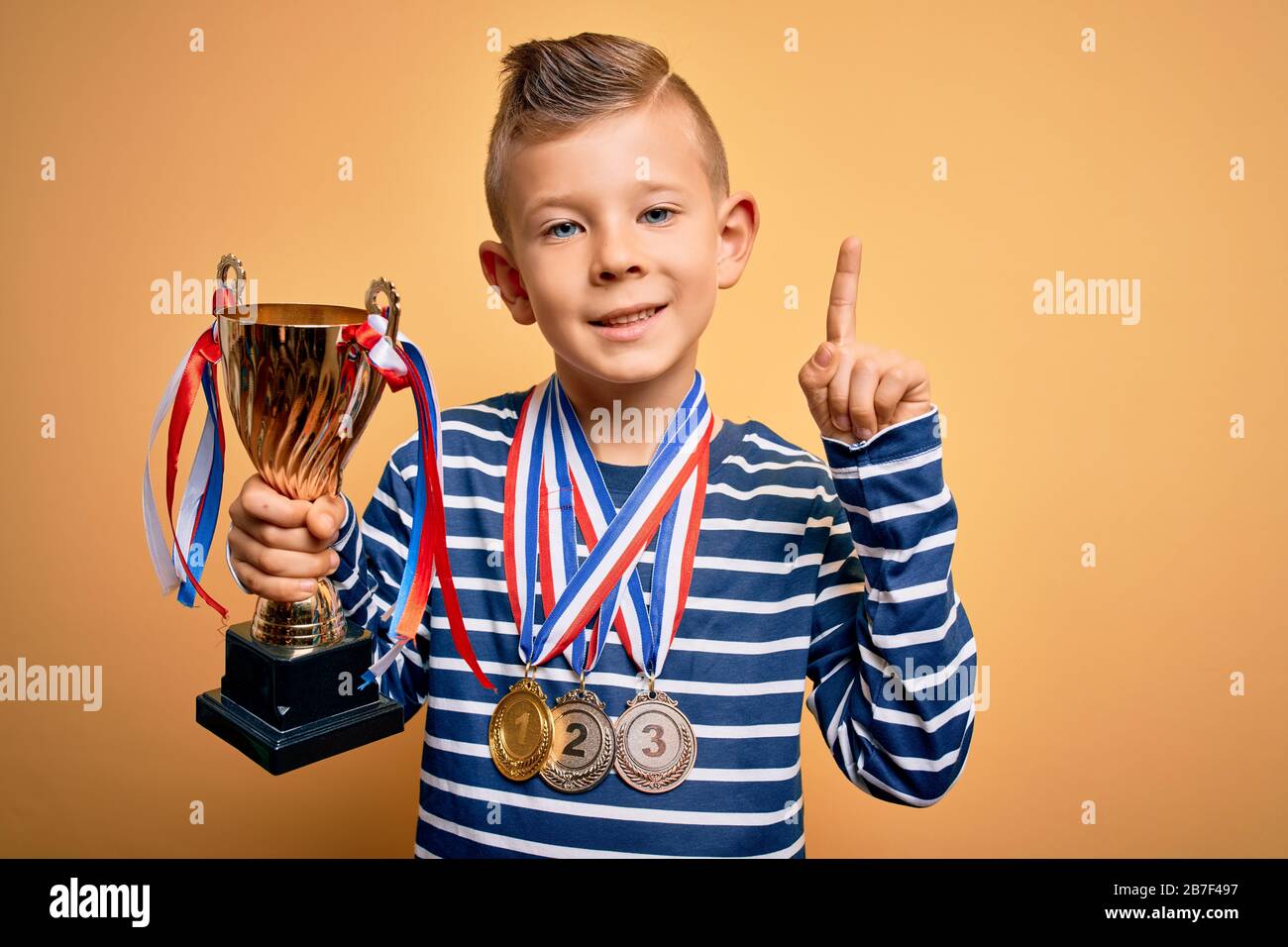Young little caucasian kid wearing winner medals and victory award ...