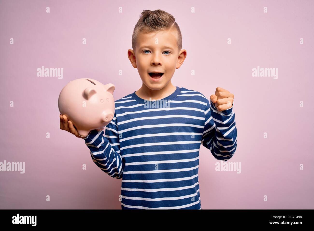 Young little caucasian kid banking money on piggy bank as wealth ...