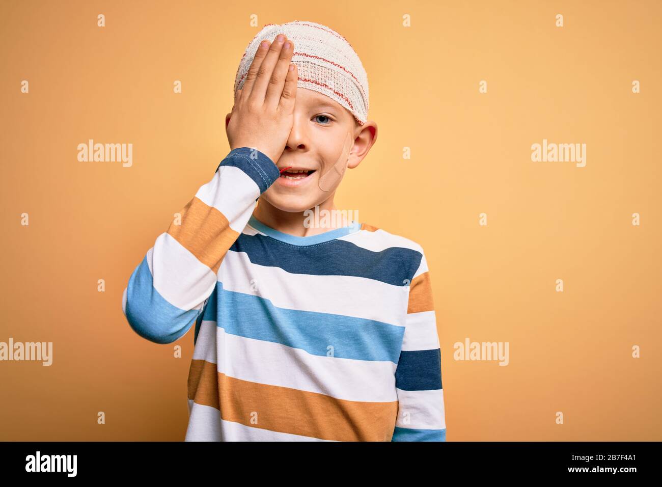 Young little caucasian kid injured wearing medical bandage on head over ...