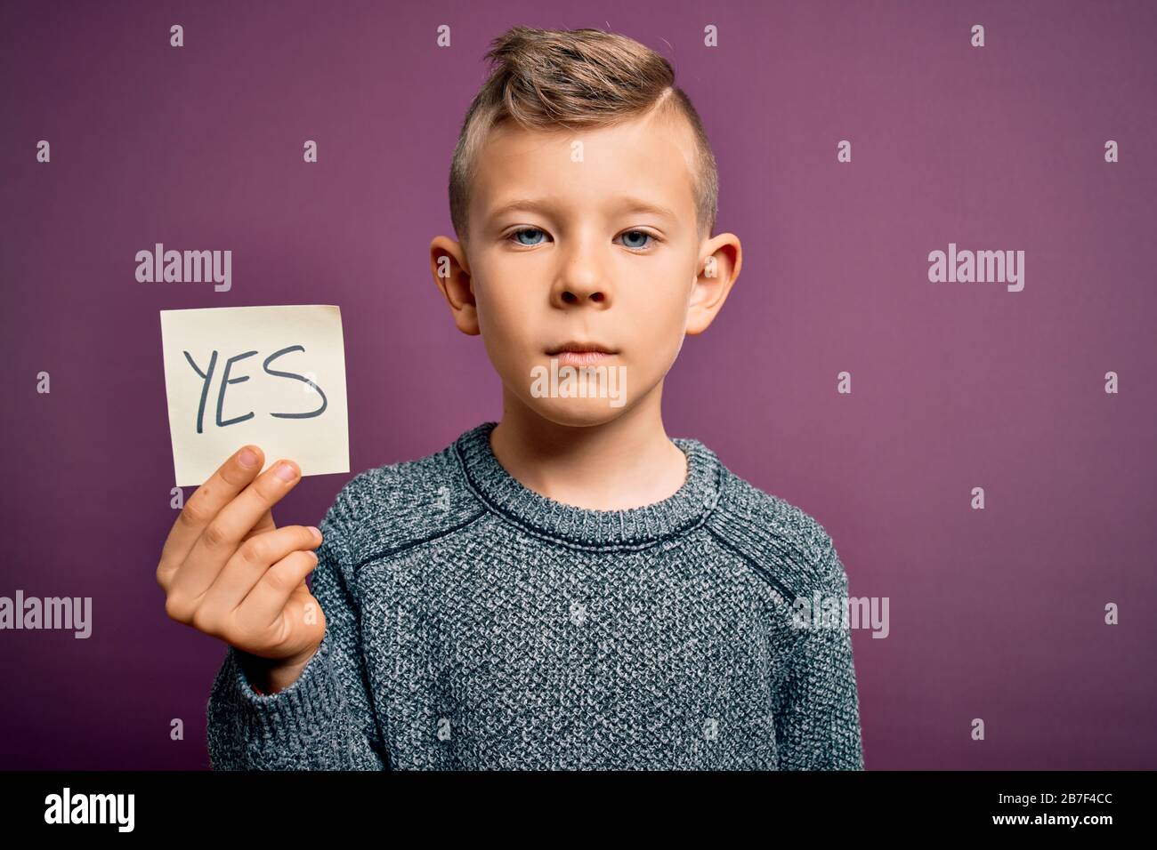 Young little caucasian kid showing YES word on a paper note as positive ...
