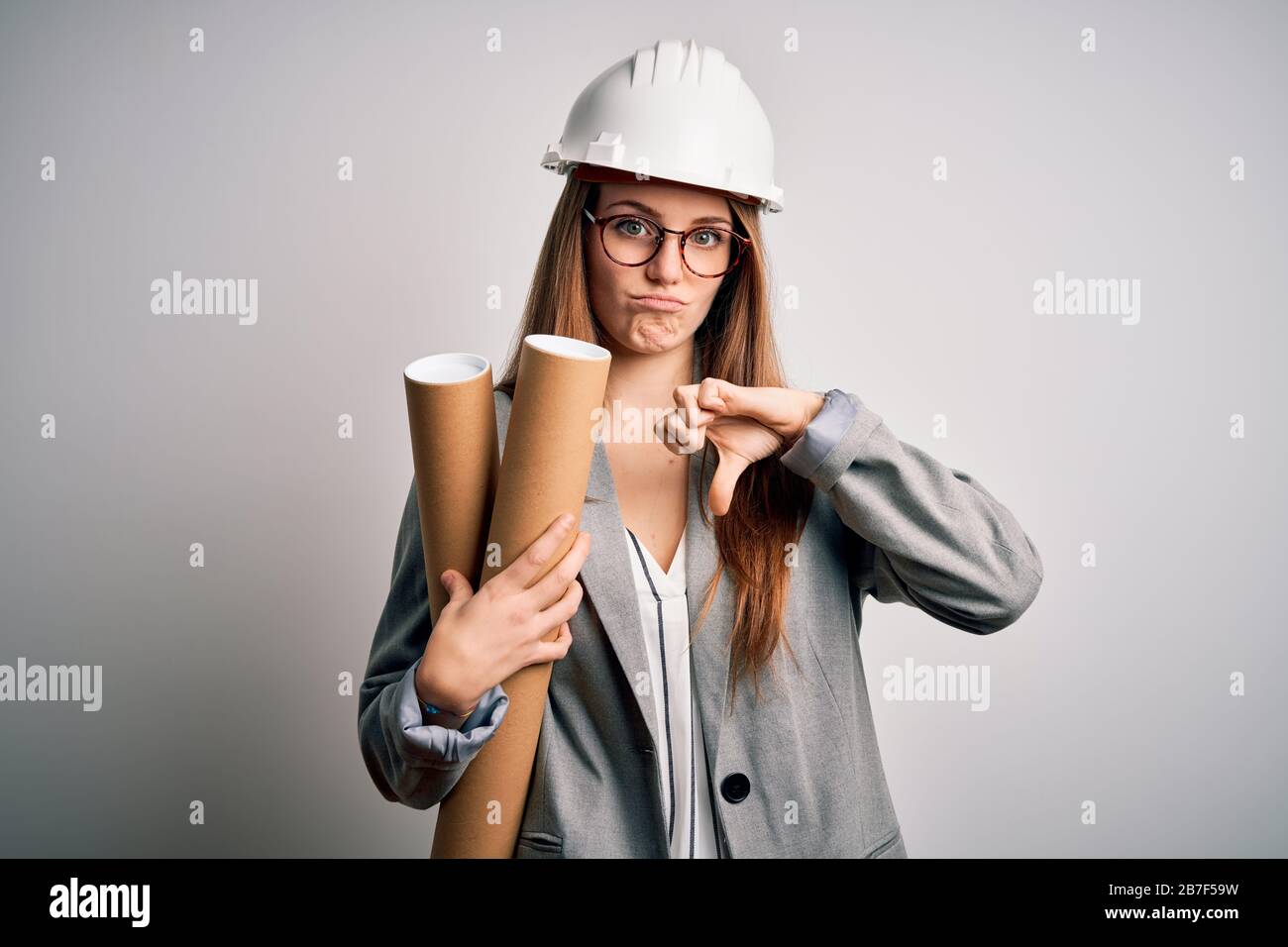 Young beautiful redhead architect woman wearing glasses and safety ... Young beautiful redhead architect woman wearing glasses and safety ...