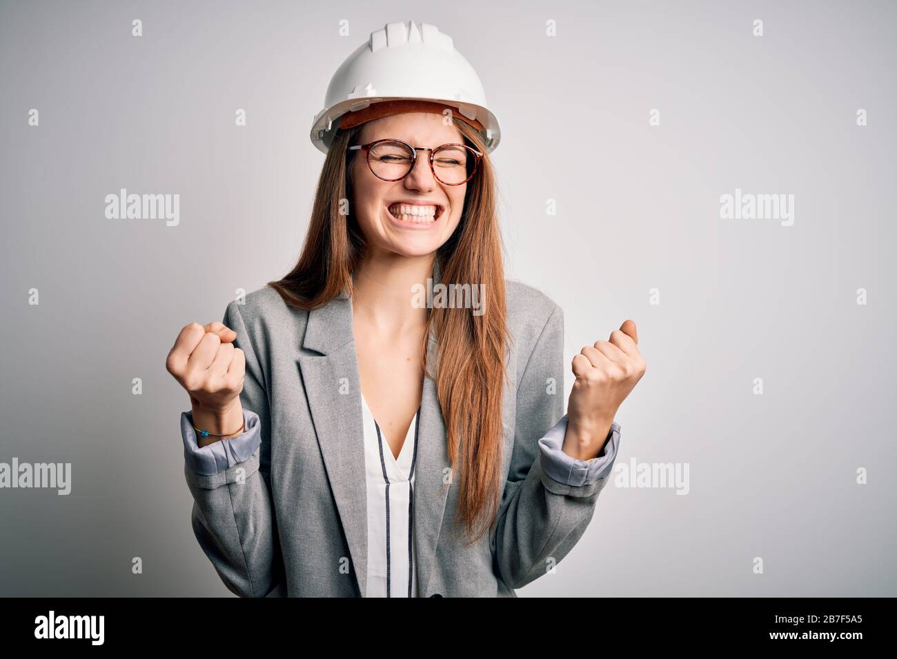 Young beautiful redhead architect woman wearing security helmet over ... Young beautiful redhead architect woman wearing security helmet over ...