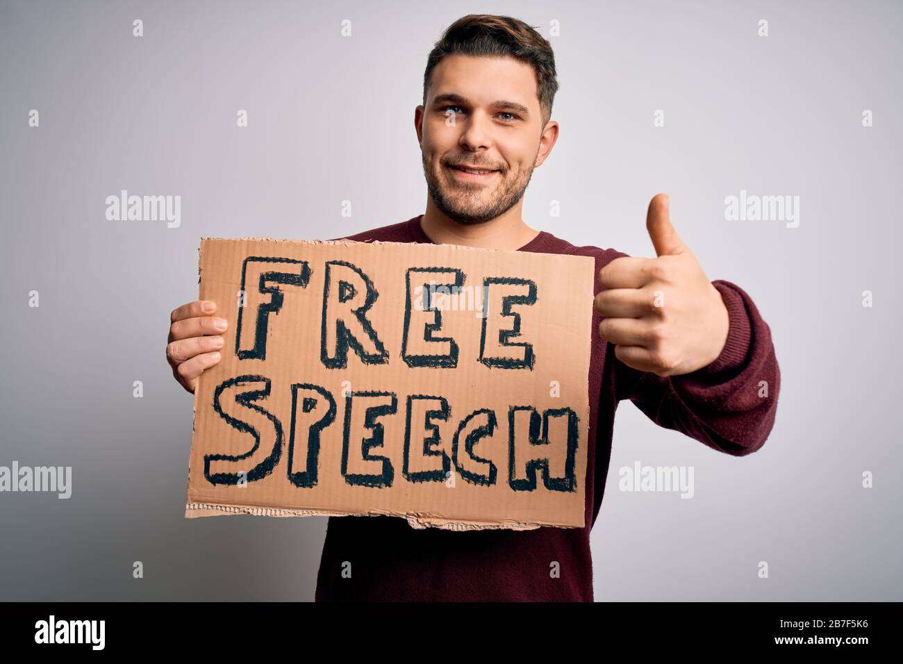 Young man with blue eyes holding banner on protest for free speech ...