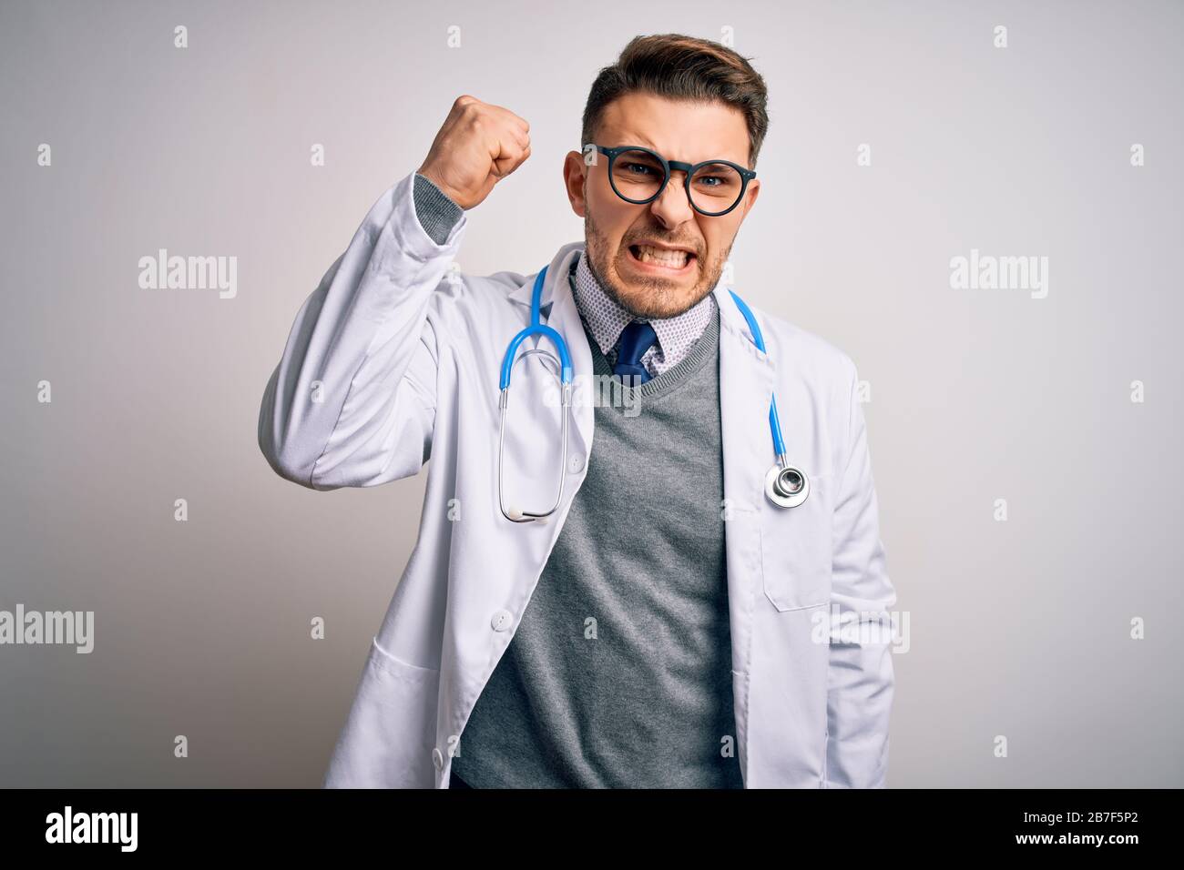Young doctor man with blue eyes wearing medical coat and stethoscope ...
