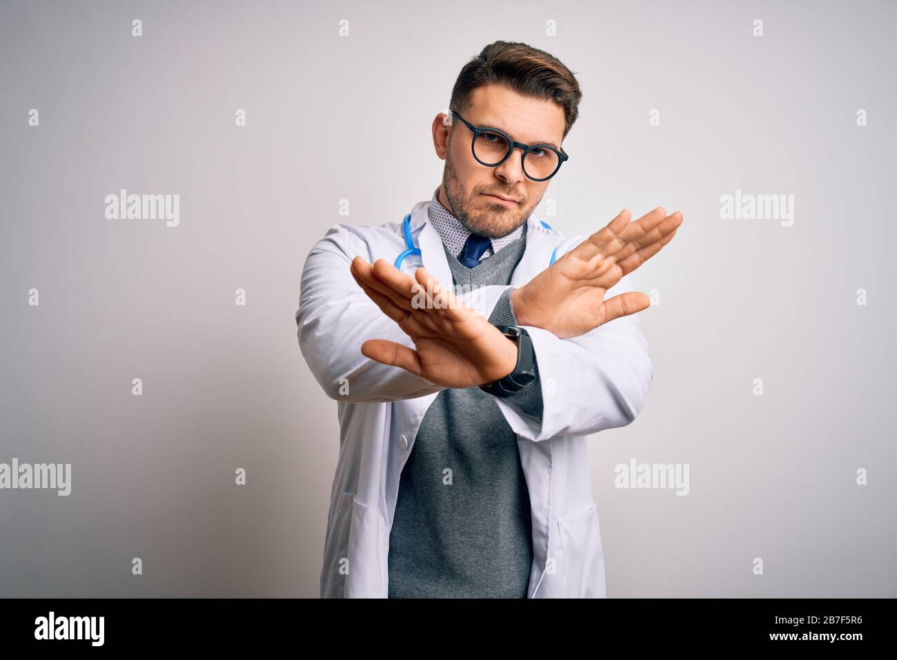 Young doctor man with blue eyes wearing medical coat and stethoscope ...