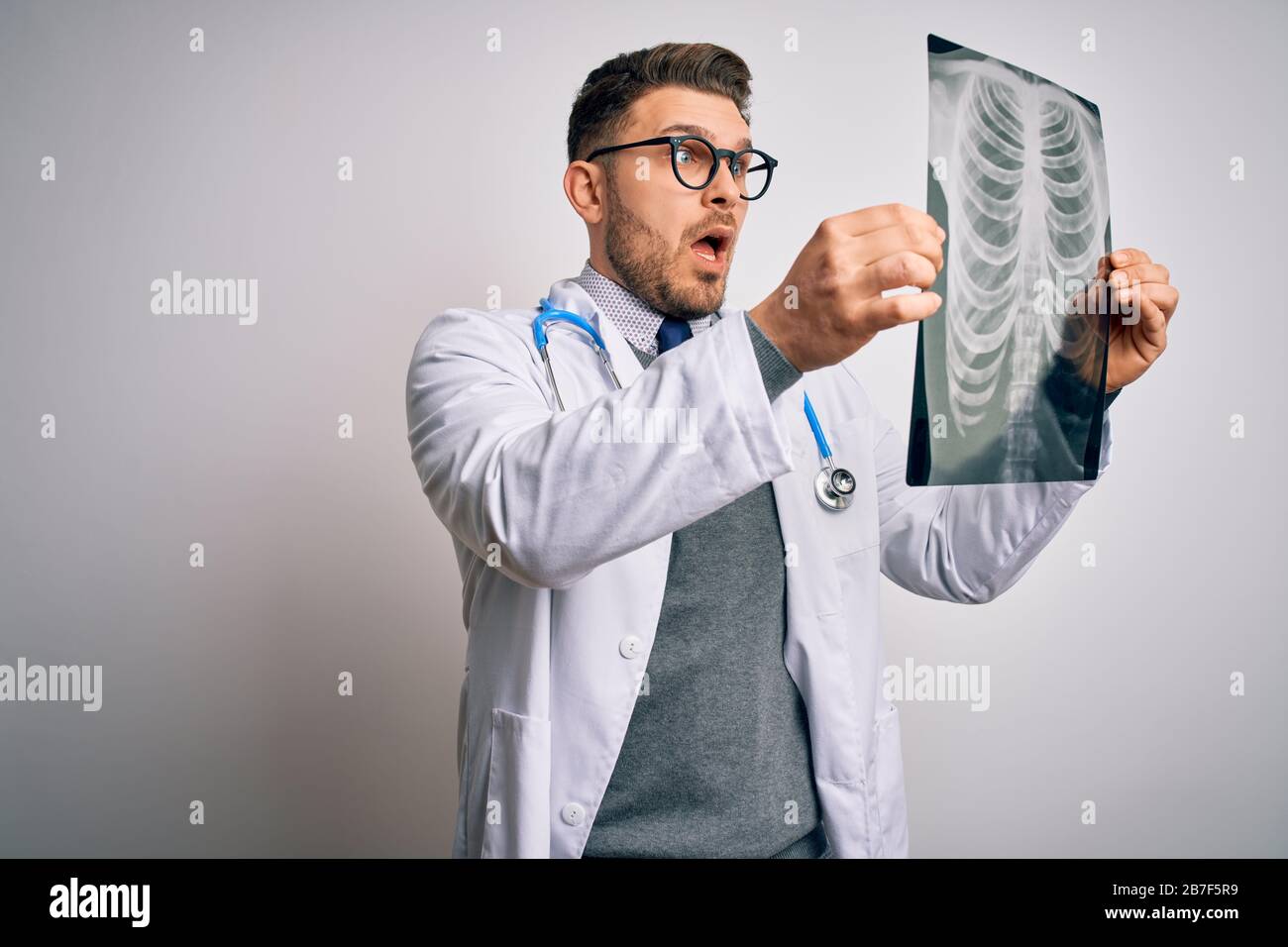 Young doctor man wearing medical coat looking at chest scan radiography ...