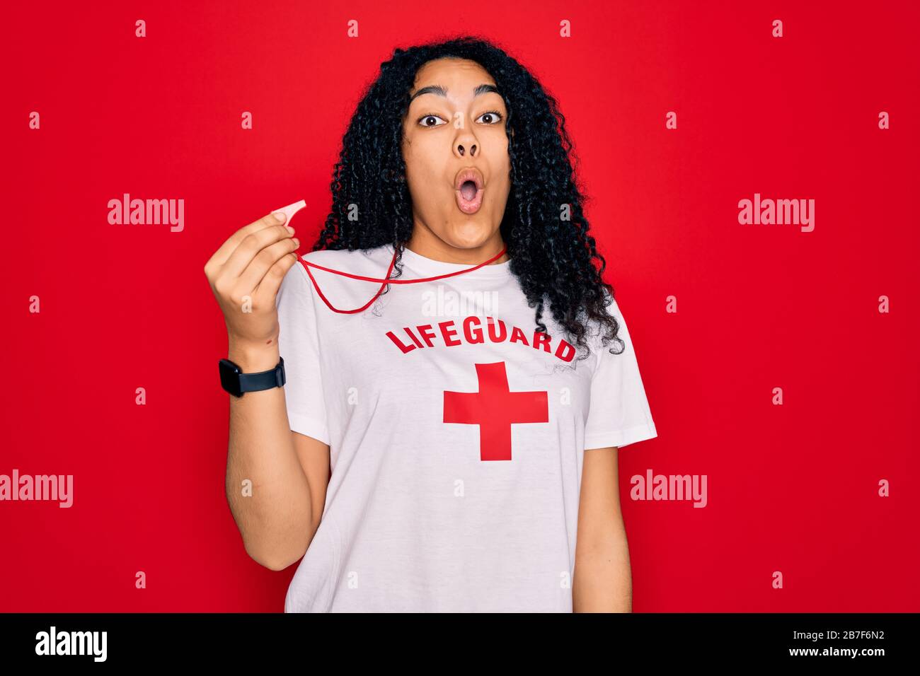 Young african american curly lifeguard woman wearing t-shirt with red ...