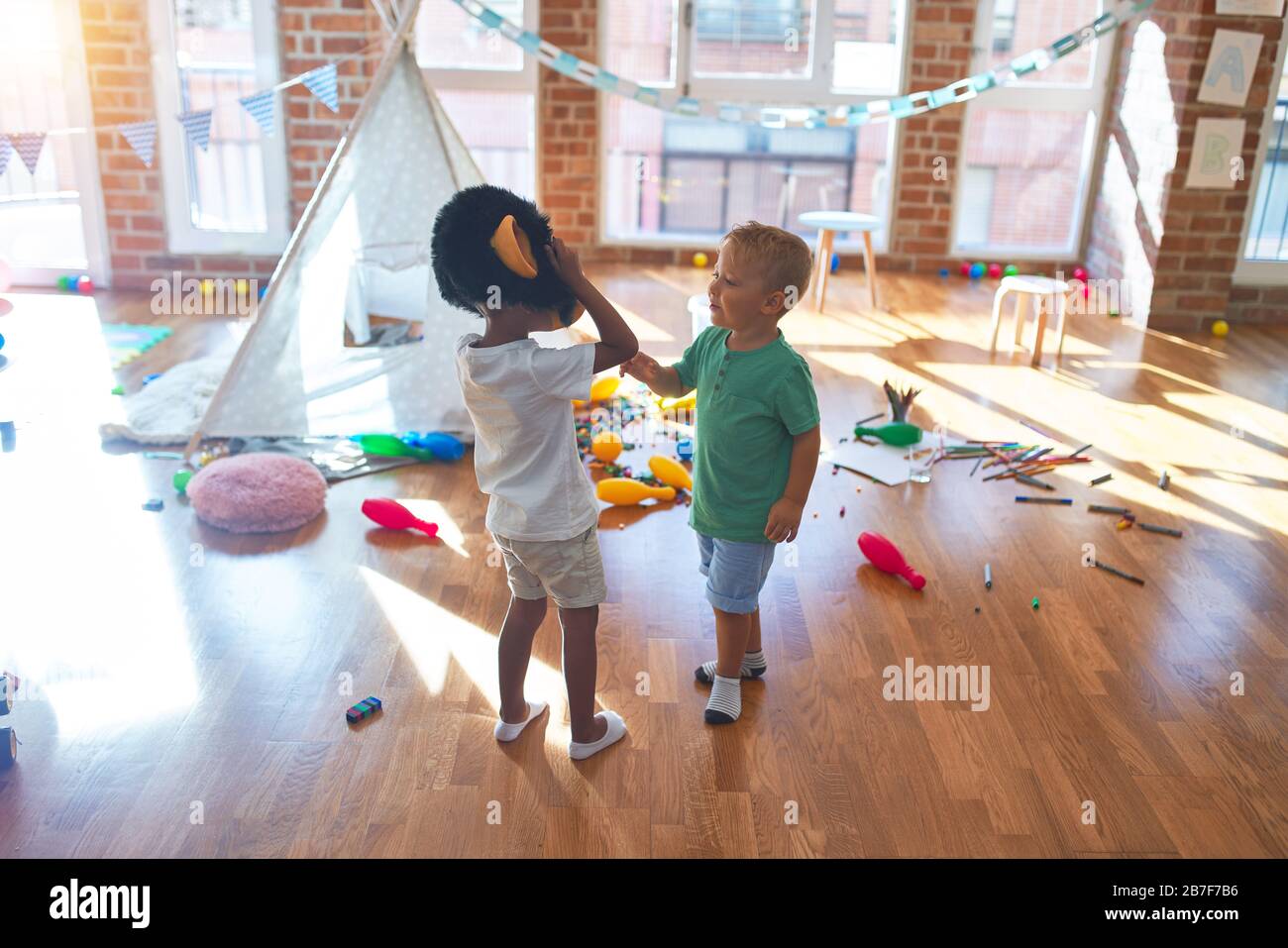 Adorable toddlers playing around lots of toys at kindergarten Stock ...